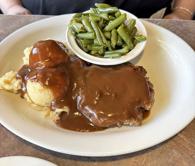 Hamburger steak swimming in gravy so good you'll want to write it love letters. Those green beans provide the illusion of virtue. 