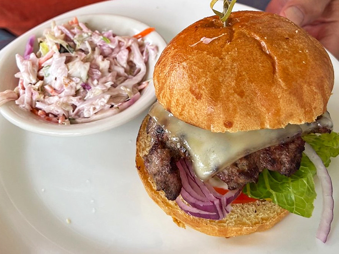 A burger that doesn't need to show off &ndash; just honest beef, melted cheese, and fresh toppings alongside creamy coleslaw that tastes like summer picnics.