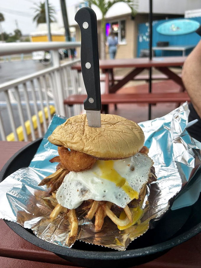 Not just a burger – it's breakfast, lunch, and possibly dinner stacked between buns with a knife as an exclamation point.