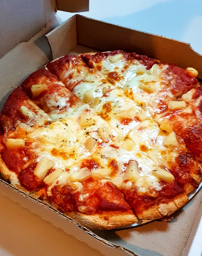 Hawaiian pizza with pineapple that even the skeptics might secretly enjoy when nobody's watching their choices.