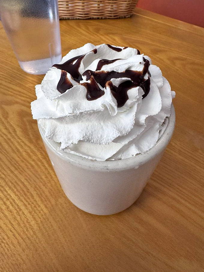 Hot chocolate that's wearing a whipped cream hat with chocolate syrup accessories—winter comfort in a mug, regardless of the actual temperature outside.