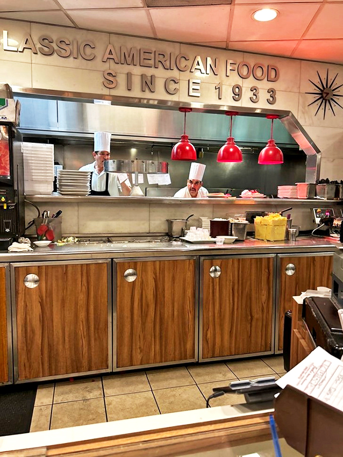 Chefs in their natural habitat, working behind that "Classic American Food" sign that's both a promise and a mission statement.