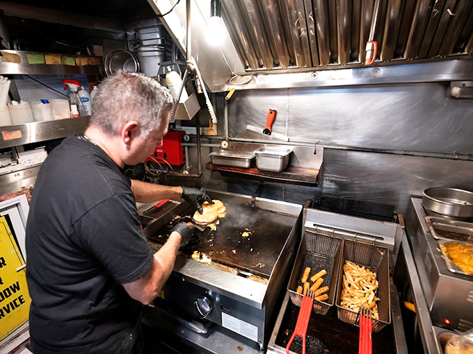 In this compact kitchen, spatial physics are defied as cooks perform a nightly ballet of flipping, seasoning, and serving with practiced precision.