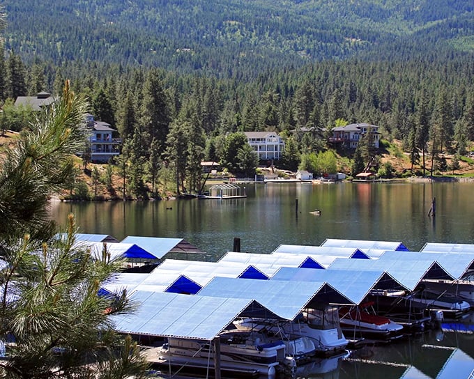 Covered boat docks protect weekend vessels while offering a geometric contrast to the organic shoreline and mountain backdrop.
