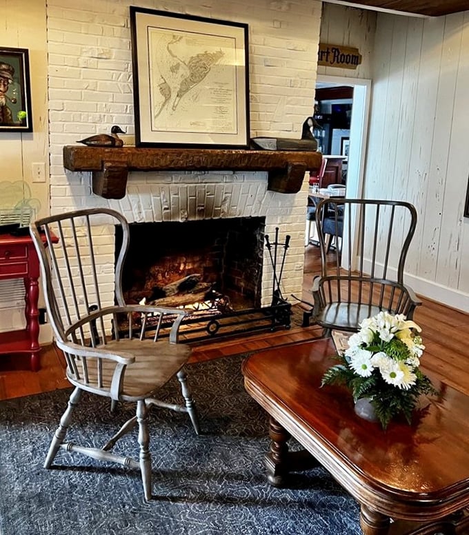 Where crackling fires meet maritime charm. This cozy corner with Windsor chairs and white-painted brick feels like a New England sea captain's actual living room. 
