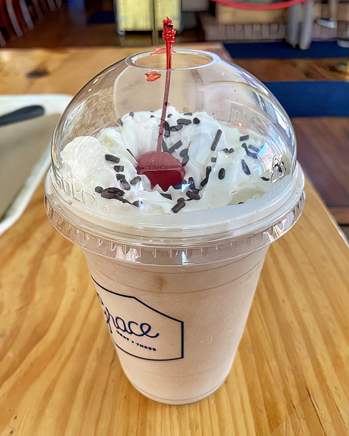This milkshake wears whipped cream and sprinkles like a jaunty hat. The cherry on top isn't just garnish—it's punctuation on a sweet statement.