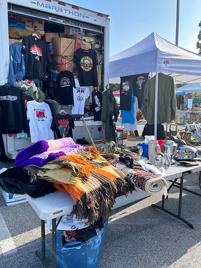 A truck becomes an impromptu boutique, with vintage band shirts and colorful textiles creating a bohemian outpost in the asphalt landscape.