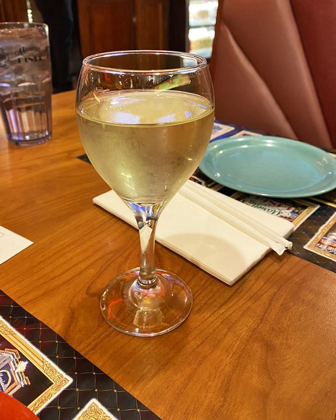 A glass of chilled Moscato sits ready, like liquid sunshine waiting to complement whatever feast you've bravely ordered from that massive menu.