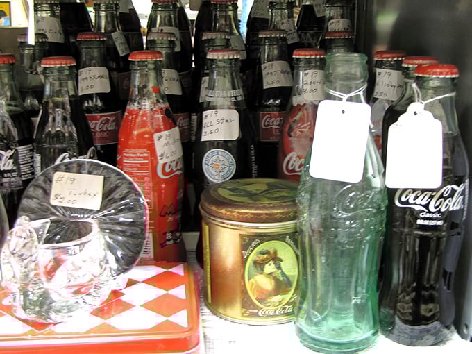 Coca-Cola bottles stand at attention like fizzy soldiers, their vintage labels and distinctive shapes chronicling America's love affair with soda.