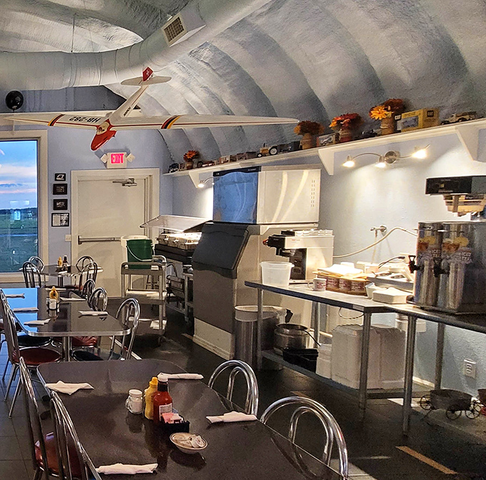 Self-service station beneath a yellow biplane&mdash;because coffee tastes better when poured under the watchful eye of vintage aircraft.