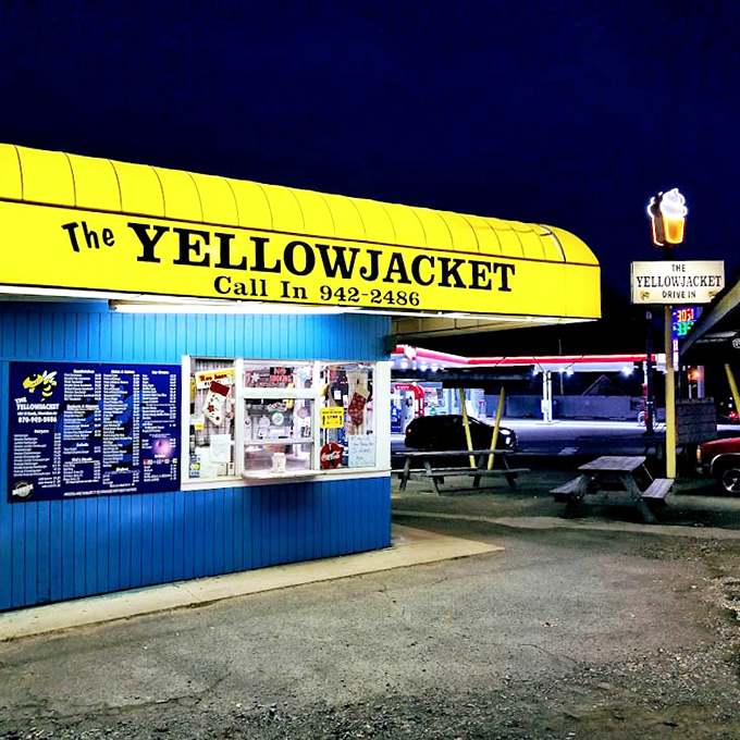 By night, the Yellow Jacket transforms into a neon-lit oasis of comfort food, beckoning hungry souls from miles around.
