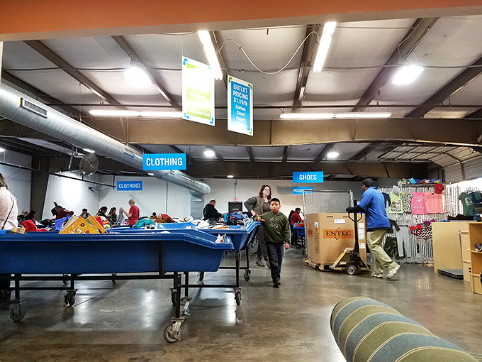 Behind the scenes where donation meets retail. The blue sorting bins are like culinary prep stations in this feast of secondhand treasures.