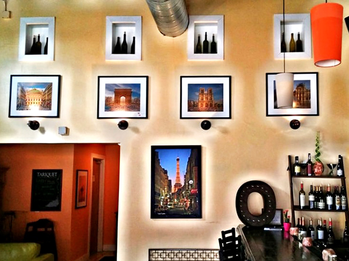 Colorful pendant lights cast a warm glow throughout the space, highlighting framed artwork that transports you to European streets.