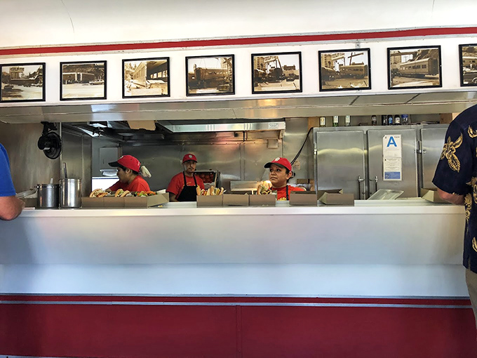 Behind the counter, culinary choreography unfolds as the staff works with the practiced precision that comes from decades of perfecting their craft.