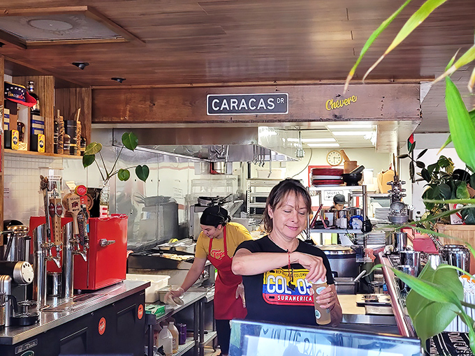 Behind the scenes where the magic happens. The "Caracas St" sign is a small but powerful reminder of the authentic flavors being crafted in this kitchen.
