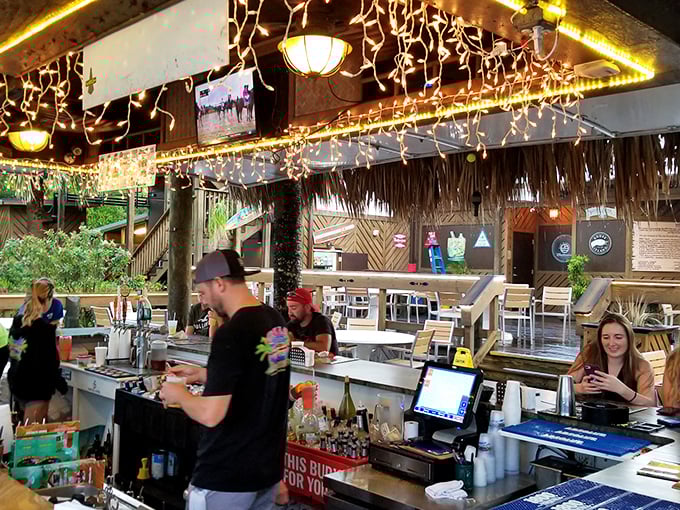 The bar staff moves with the choreographed precision of people who know exactly how to turn spirits into happiness.