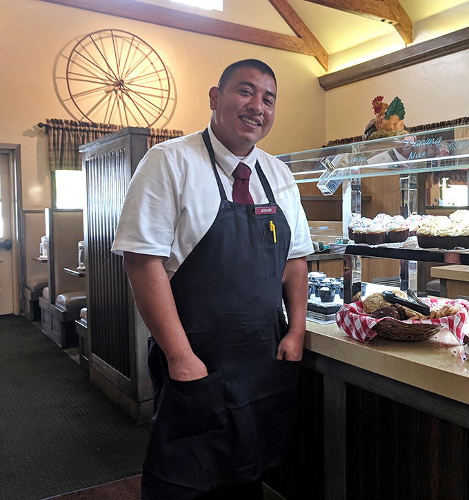 Behind every great buffet stands a proud staff member, guardian of the sacred covenant between hungry guests and home cooking.