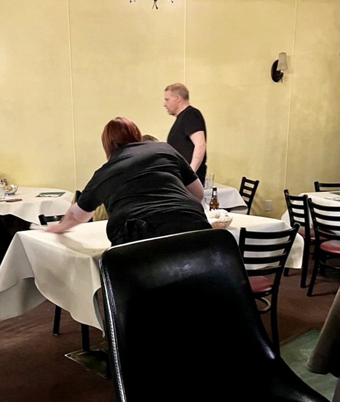 Staff preparing tables with care&mdash;the kind of attentive service that comes from pride rather than corporate training manuals.