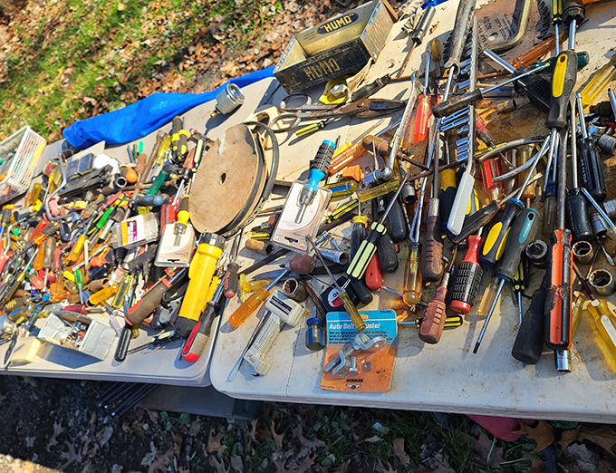 Tool paradise where forgotten screwdrivers and hammers await their next project. A hardware store exploded onto this table!