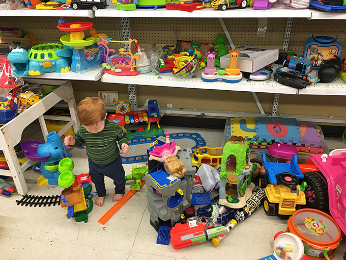 A tiny explorer discovers the toy section's treasures, proving that childhood wonder comes at thrift store prices.