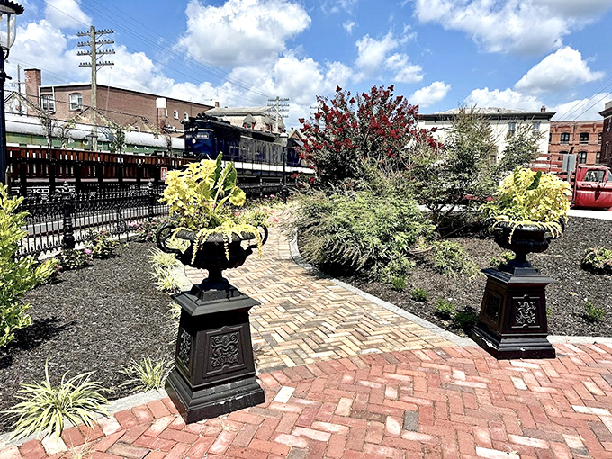 Garden elegance frames the railway experience, proving that industrial history and botanical beauty make surprisingly good travel companions.
