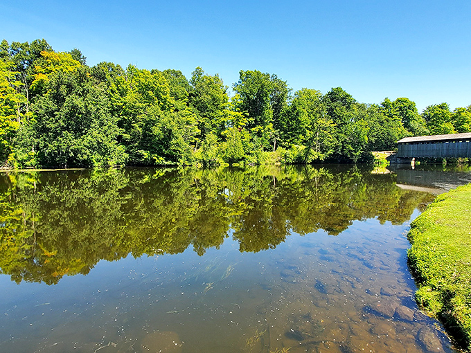 The Flat River's glassy surface perfectly mirrors the surrounding greenery, creating a moment of symmetry worth pulling over for.