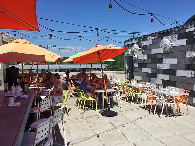 The rooftop patio offers a splash of vibrant color with its umbrellas, proving that vitamin D and mimosas might be the perfect nutritional combination.