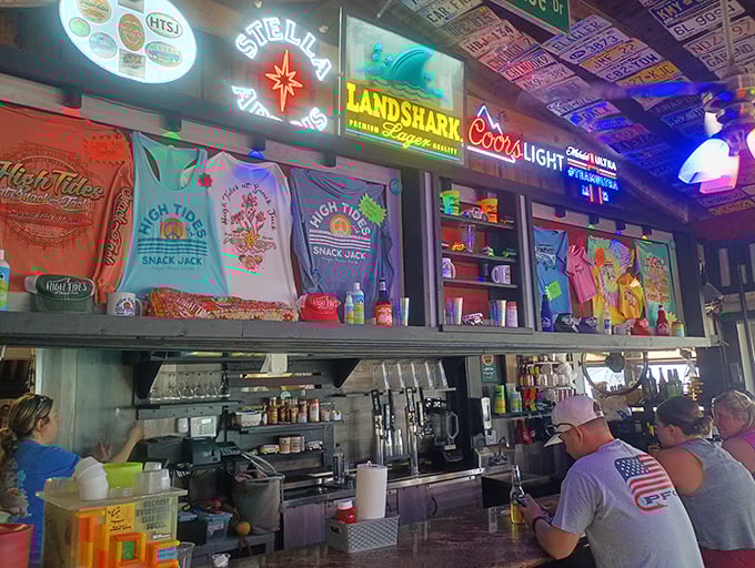 The bar area&mdash;where neon signs, colorful t-shirts, and cold drinks create the perfect backdrop for stories that get better with each telling.