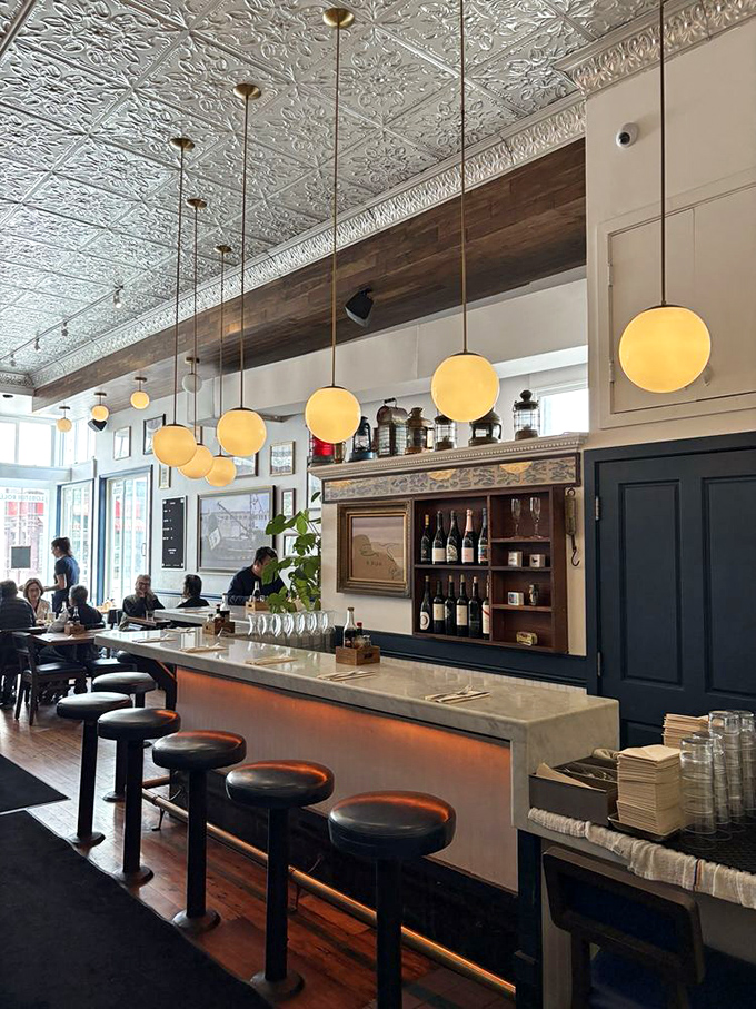 The bar at Woodhouse isn't just serving drinks&mdash;it's offering front-row seats to the seafood symphony happening in this narrow slice of heaven.