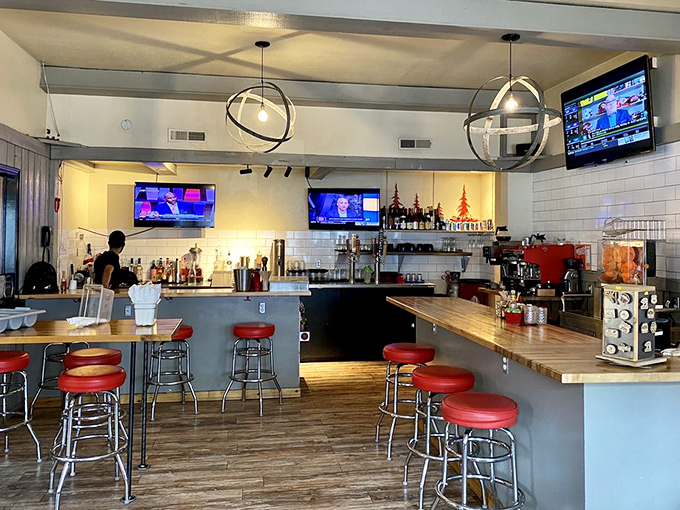 The bar area balances mountain casual with modern touches&mdash;red stools inviting you to perch and share slope stories.