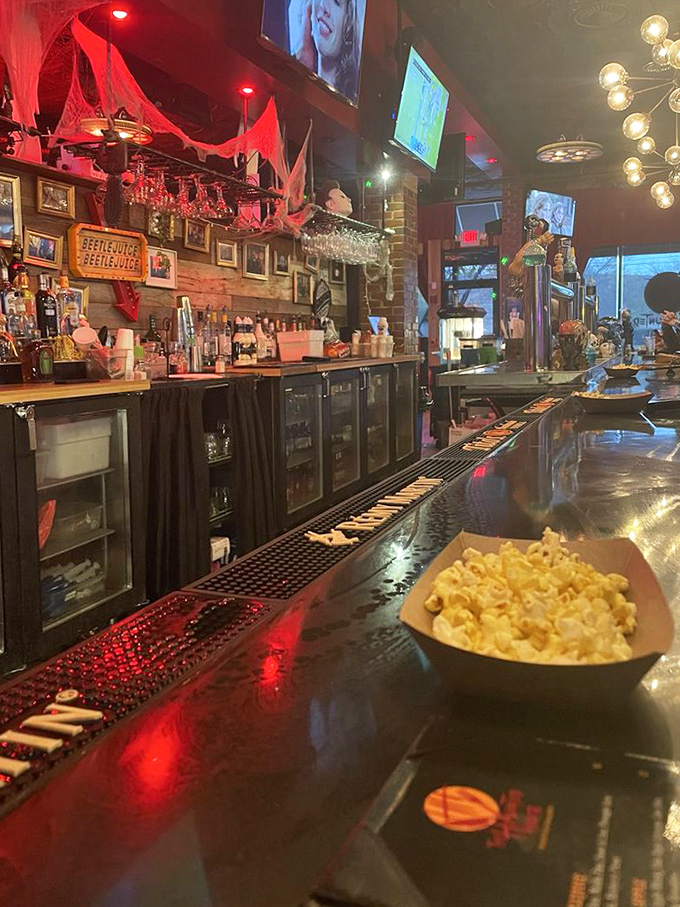 The bar area, where "spirits" take on a whole new meaning. Red lighting casts an otherworldly glow that makes even a simple popcorn snack feel like a special effect.