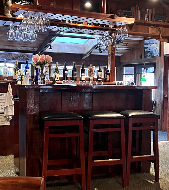 The bar isn't just where drinks are served—it's command central for wine glasses hanging like crystal stalactites above bottles promising perfect pairings.