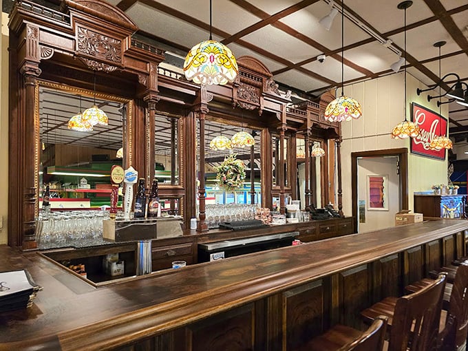 The bar area marries old-world craftsmanship with Tiffany-style lamps, creating the perfect spot to sip something while waiting for your table.