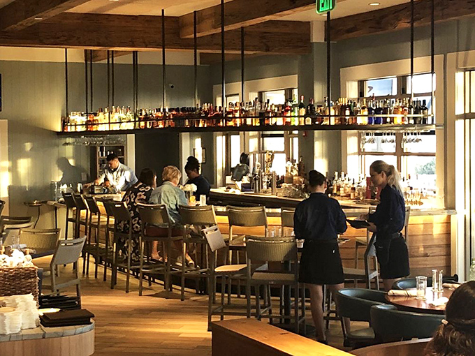 The bar where strangers become friends and cocktails become memories. Bottles gleam like jewels under thoughtful lighting.