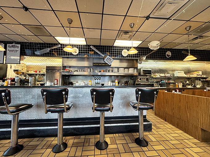 The diner's heart&mdash;where coffee flows, orders fly, and conversations bloom. Notice the flowers adding a touch of homey warmth to the stainless steel efficiency.