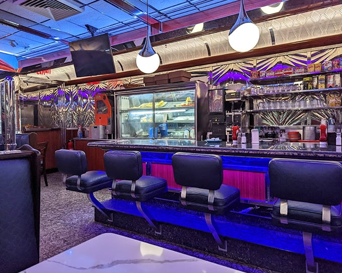 The counter seating area glows with neon ambiance, perfect for late-night philosophical discussions over pie and coffee.
