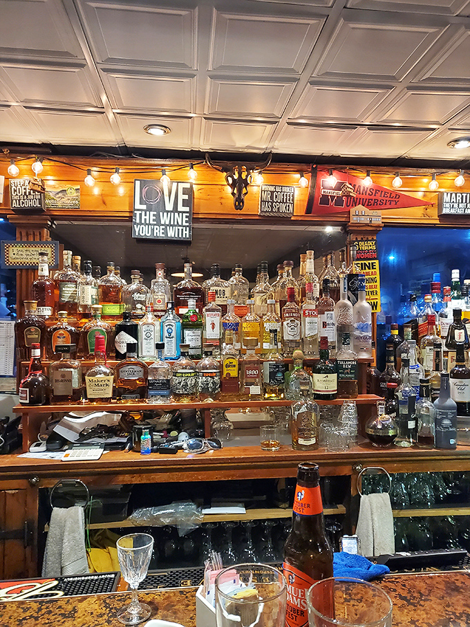 A back bar stocked for every possible mood, from "celebrating a promotion" to "drowning sorrows after the Eagles lose." That sign speaks universal truth.