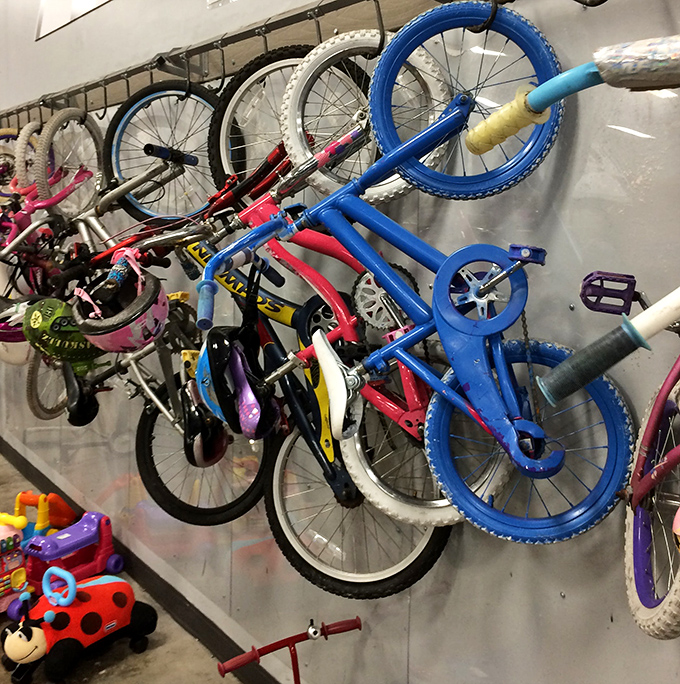 Bicycles hang like colorful metal sculptures, each one a childhood memory waiting to be recreated or an eco-friendly commute in disguise.