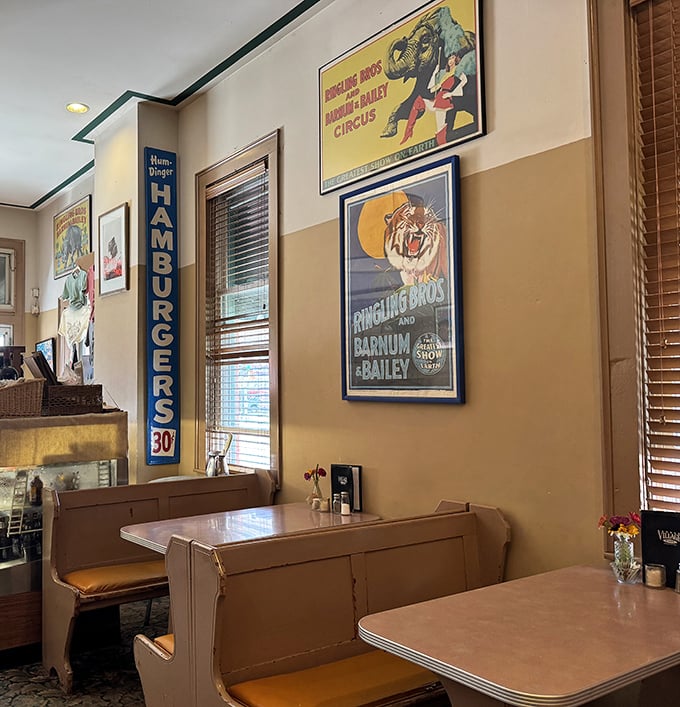 Vintage circus posters and warm wood tones create the perfect backdrop for memory-making meals. That "Hamburgers 30&cent;" sign is pure nostalgic charm.