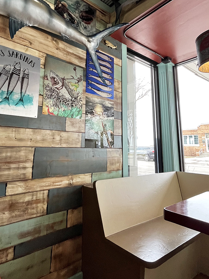 Weathered wood walls adorned with maritime art create cozy nooks where seafood dreams come true, one bite at a time.