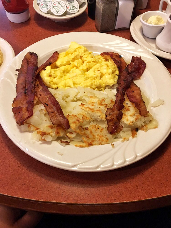 The breakfast trinity &ndash; eggs, bacon, and hash browns &ndash; performing their morning miracle with the synchronicity of a veteran jazz trio.