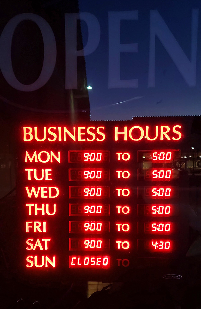 The glowing business hours sign—memorize these times like they're the combination to your savings account. Closed Sundays for treasure restocking.