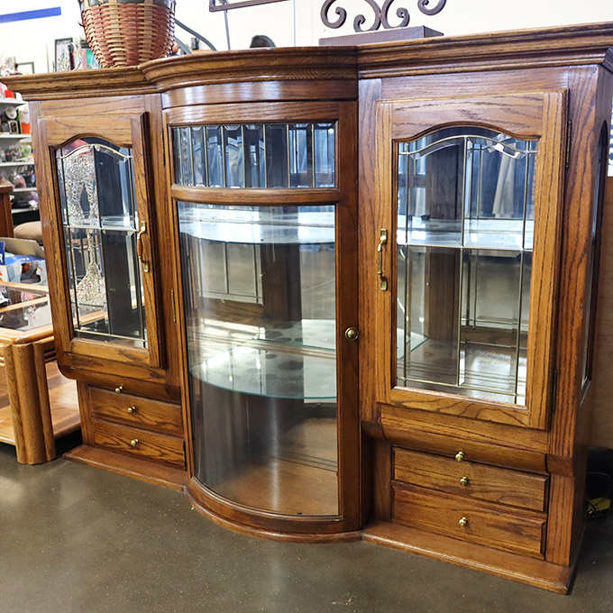 Curved glass and warm oak create a display cabinet that whispers tales of Sunday dinners and grandmother's prized collectibles from another era.