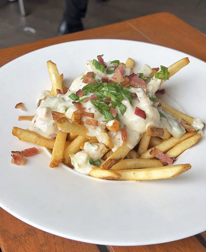 Loaded chowder fries—where French fries decided to dress up fancy with clam chowder, bacon bits, and green onions.