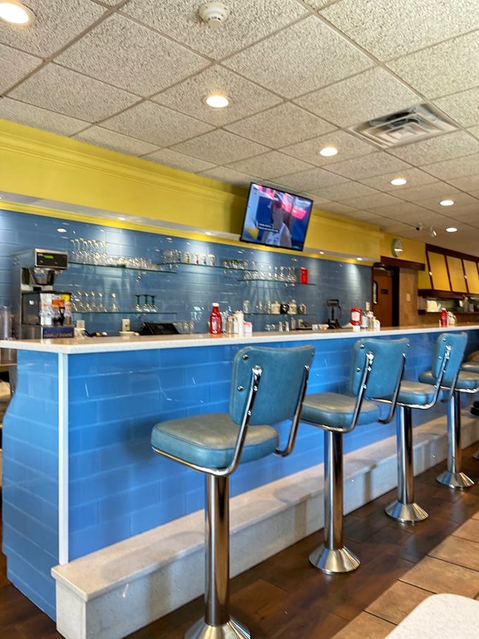 The counter's blue tile backdrop creates the perfect stage for breakfast theater, where coffee refills are the standing ovation.