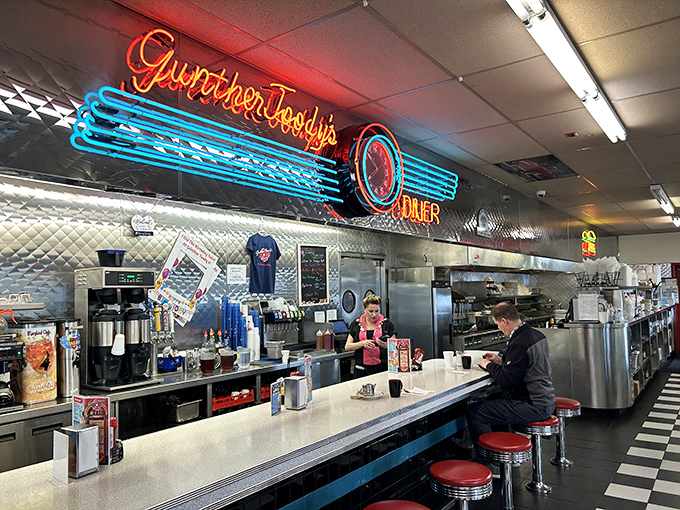The counter where milkshake magic happens. That neon sign isn't just decoration&mdash;it's a beacon guiding hungry travelers to their salvation, one stool at a time.