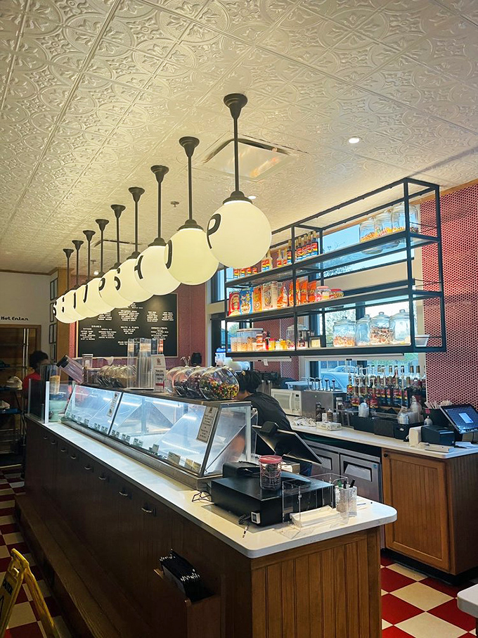 The ice cream counter where childhood dreams and adult indulgences meet under the glow of perfectly spaced pendant lights.