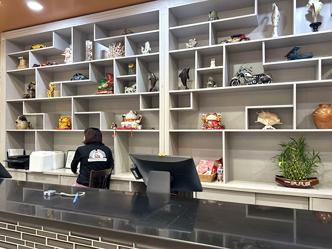 A display shelf filled with decorative treasures creates a homey backdrop to the dining experience. Someone's collection adds personality to the proceedings.