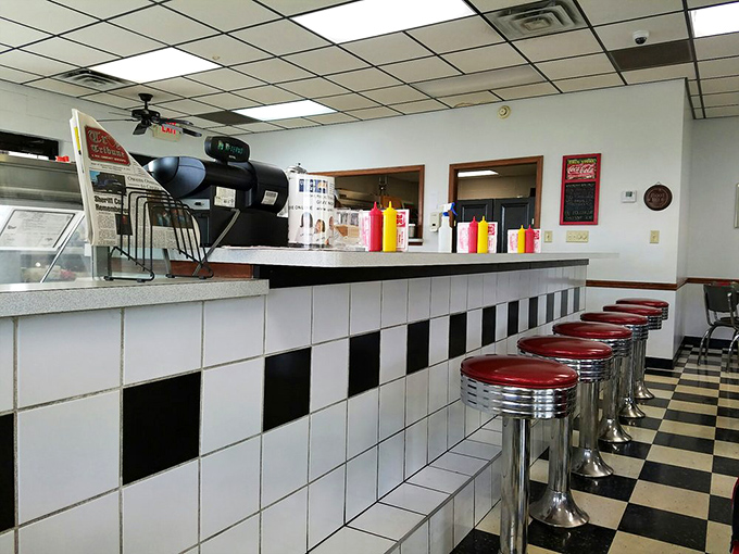 The counter's black and white tile pattern continues the nostalgic theme, with classic diner stools inviting you to belly up for a quick meal or leisurely conversation.