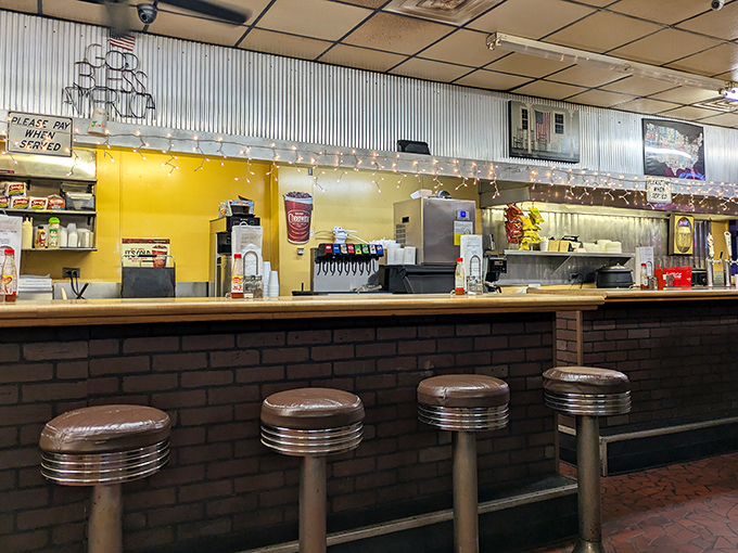 The counter seating offers front-row tickets to the culinary show—where soda fountains, coffee pots, and the promise of comfort food create the perfect American diner symphony.